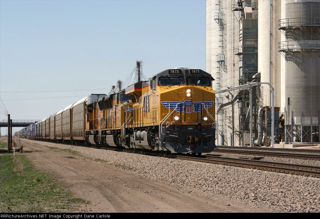 UP 7875 is keeping to schedule as it leads a mixed Auto/Stacktrain east.